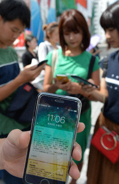 Disaster drill sending emergency alerts to mobile phones held in Osaka ...