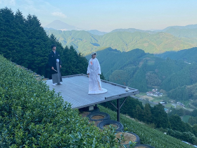 Newlyweds pose for photos on terrace overlooking tea fields in central ...
