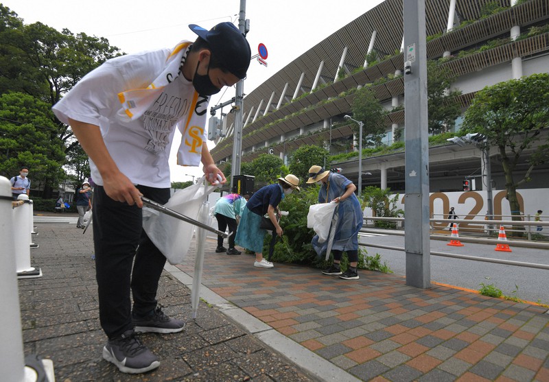 Tokyo residents collect trash around Olympic stadium to give world warm ...