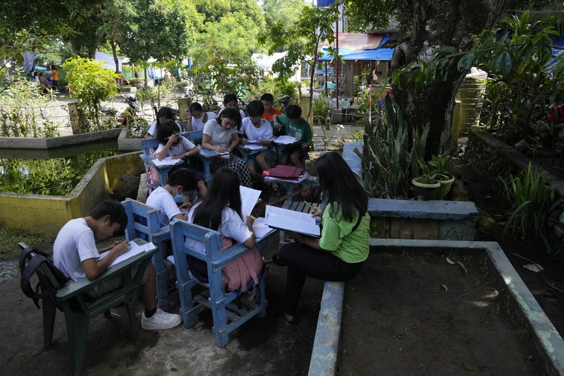 Students meet under trees as schools shelter villagers displaced by ...